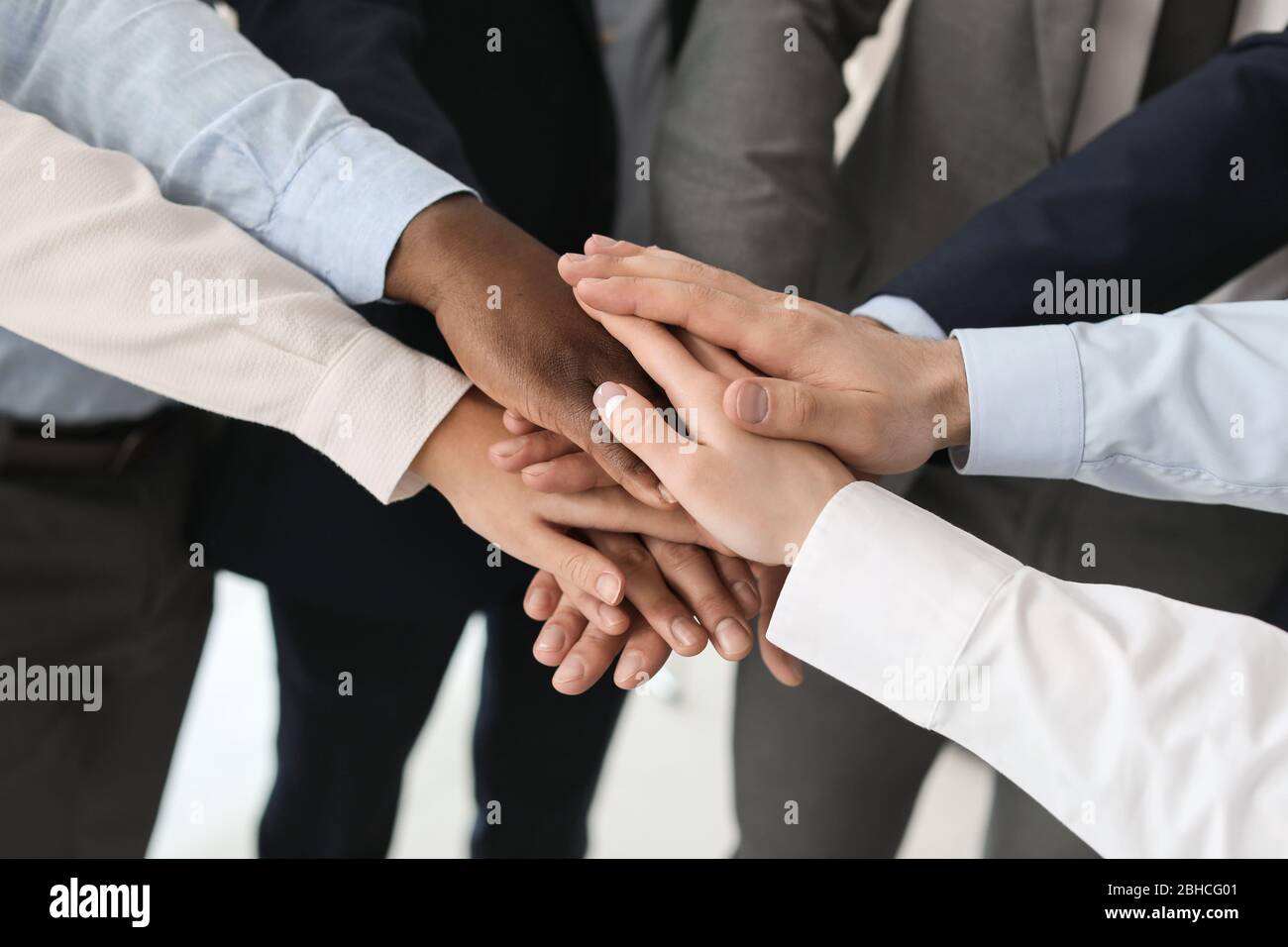 Group of business people putting hands together in office. Unity ...