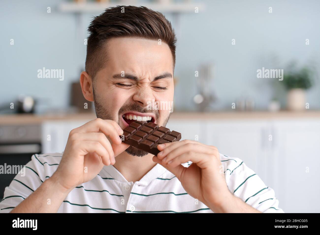 Man eating chocolate bar and happy hi-res stock photography and images ...