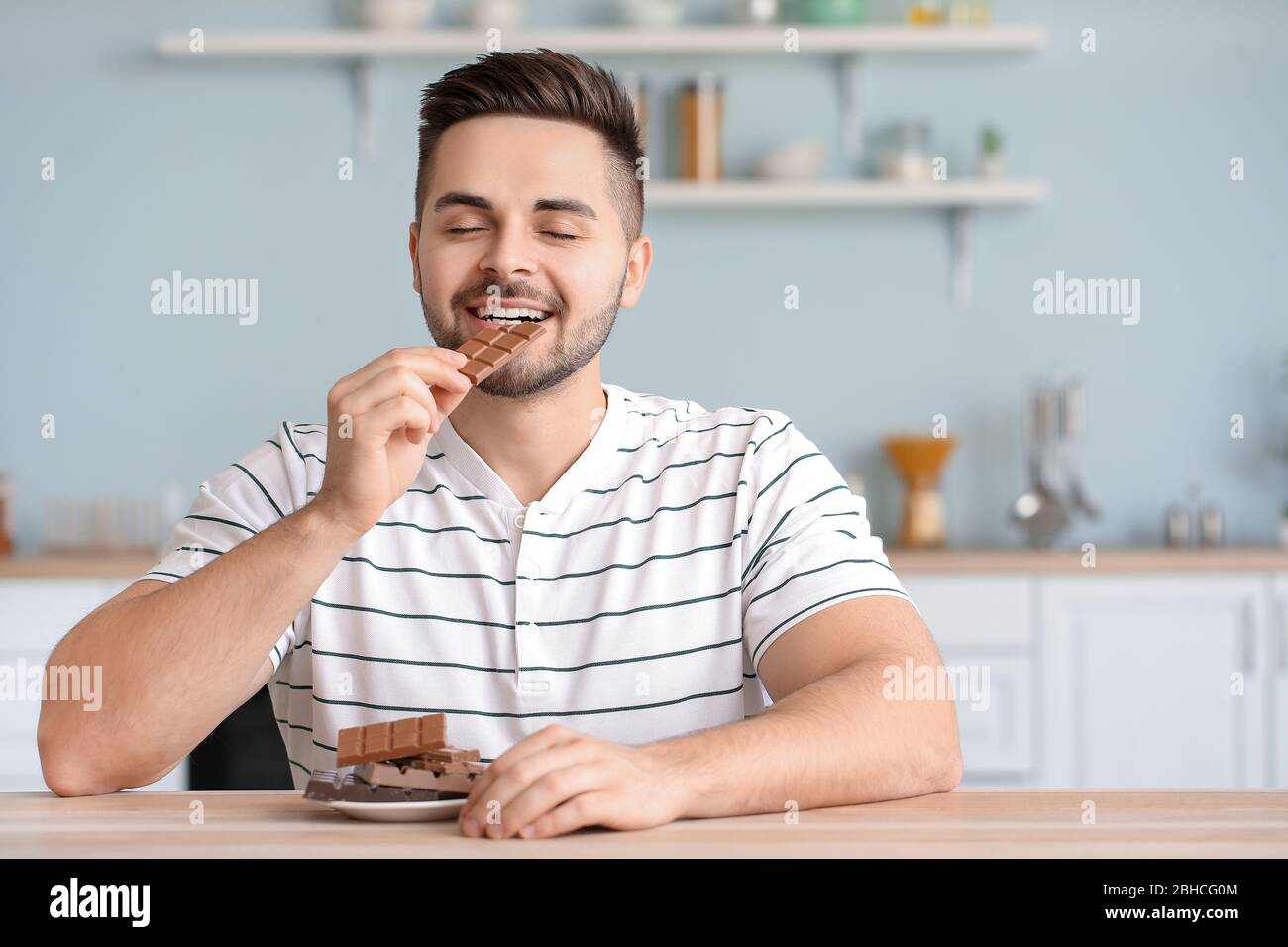Guy eating chocolate bar and happy hi-res stock photography and images ...