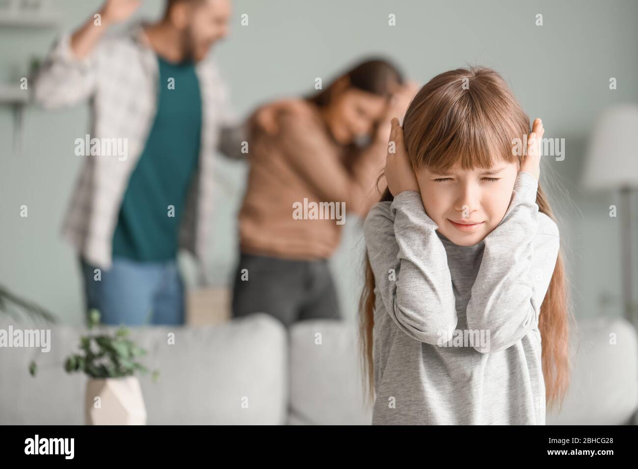 Sad little girl and her quarreling parents at home Stock Photo - Alamy