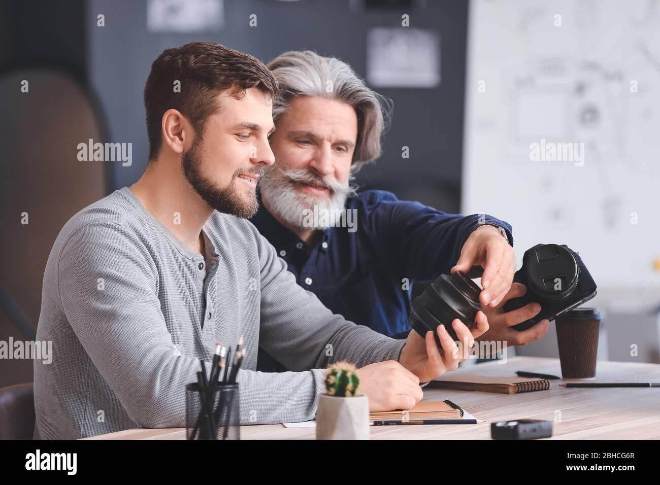 Mentor teaching young photographer in studio Stock Photo - Alamy