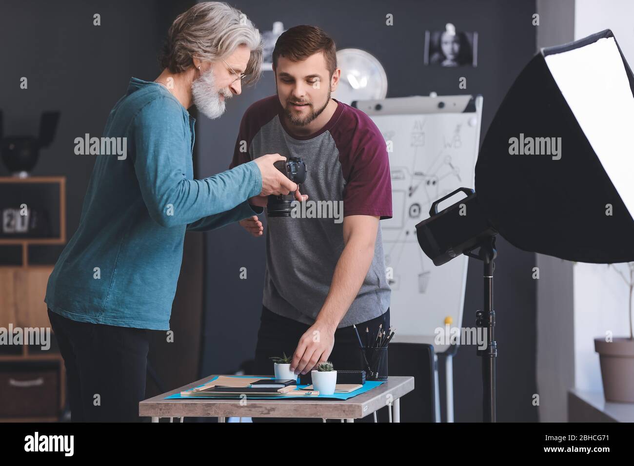 Mentor teaching young photographer in studio Stock Photo - Alamy