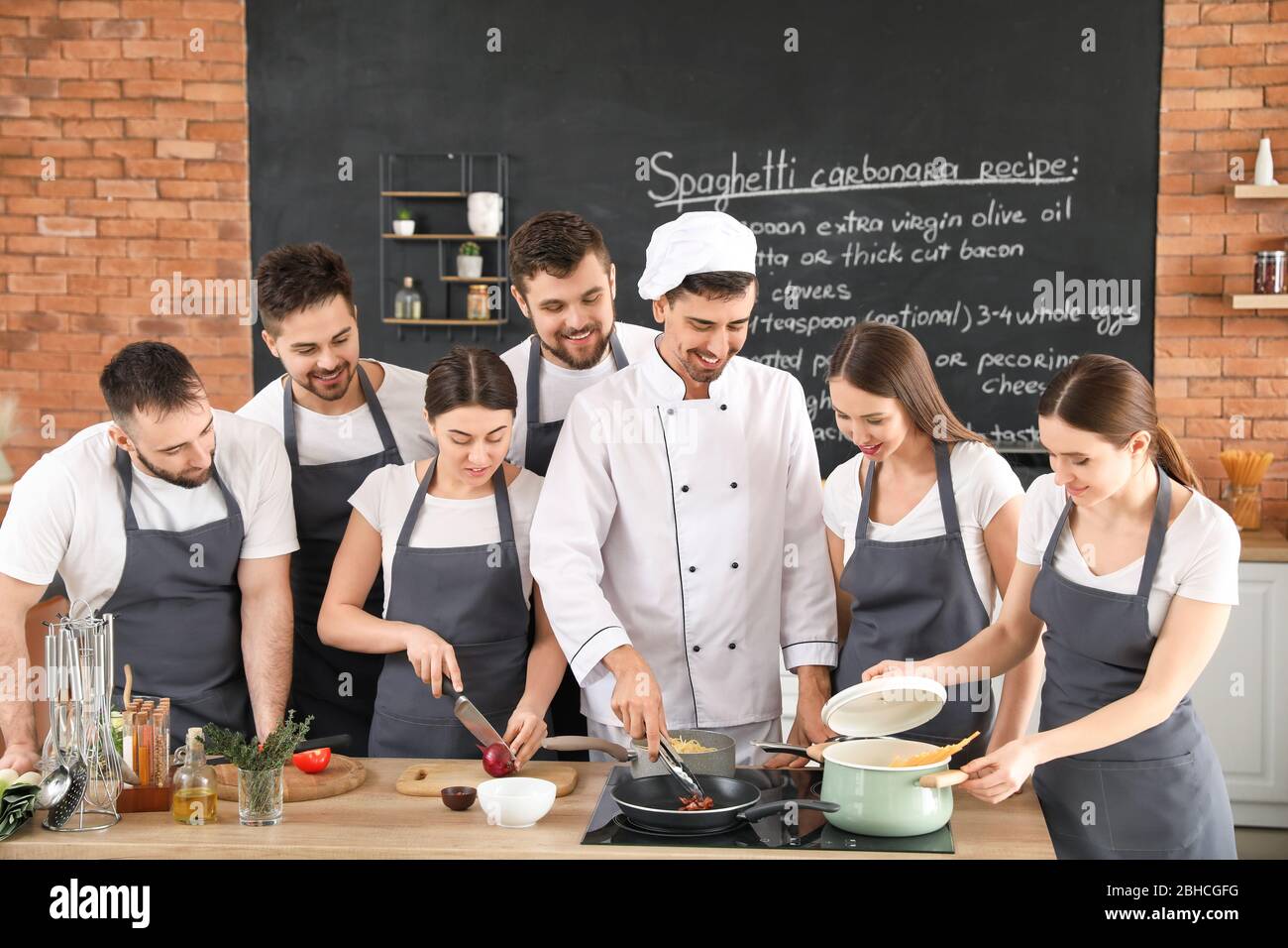 Male chef and group of young people during cooking classes Stock Photo ...
