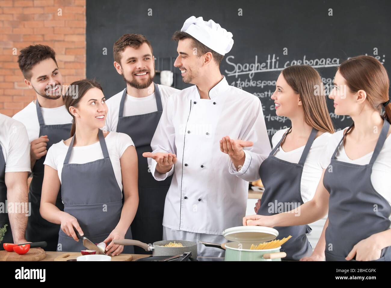 Male chef and group of young people during cooking classes Stock Photo ...