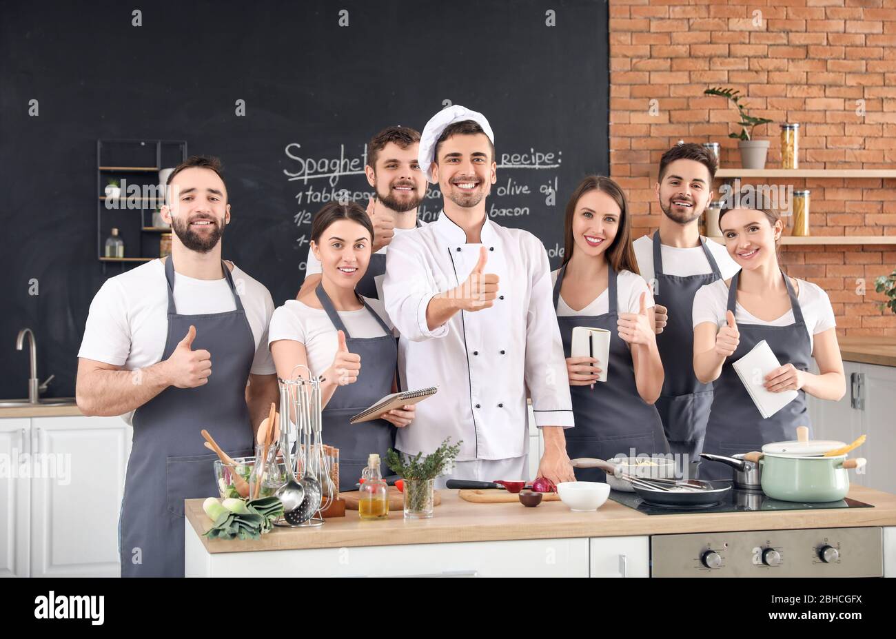 Male chef and group of young people during cooking classes Stock Photo ...