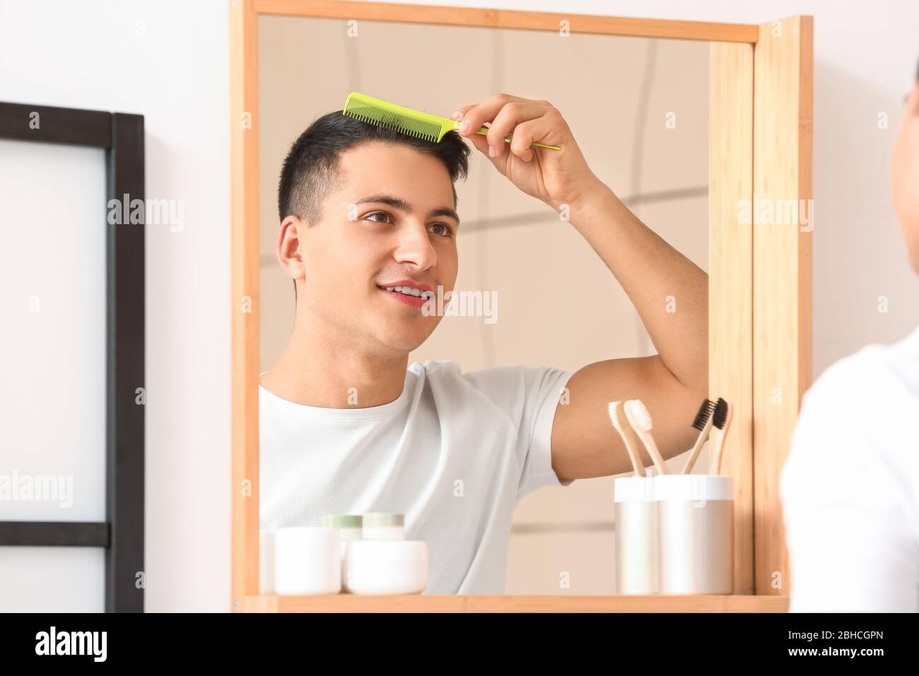 Handsome young man combing hair hi-res stock photography and images - Alamy