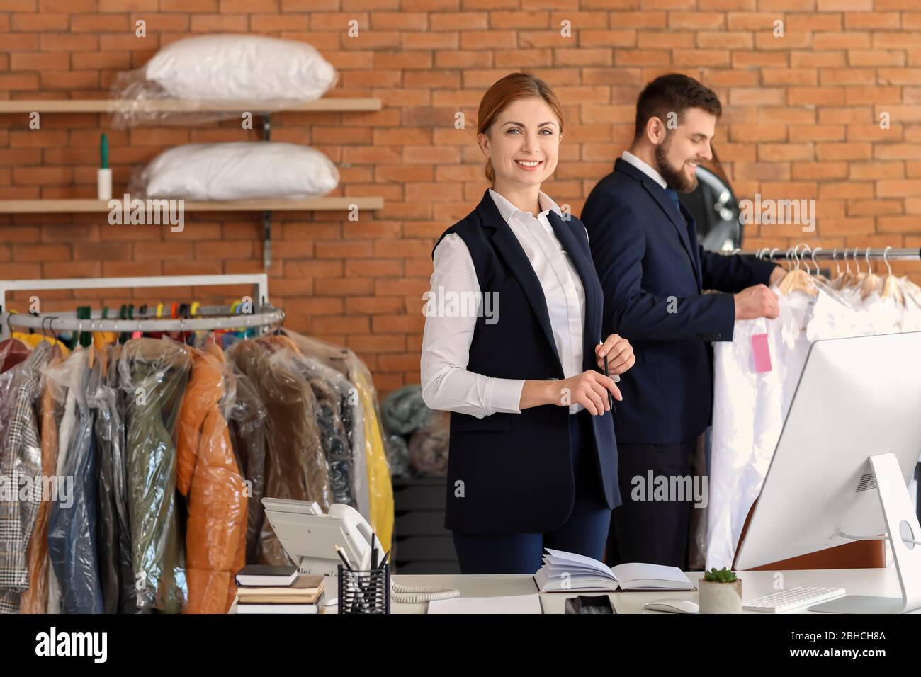 Workers of modern dry-cleaner's at reception Stock Photo - Alamy