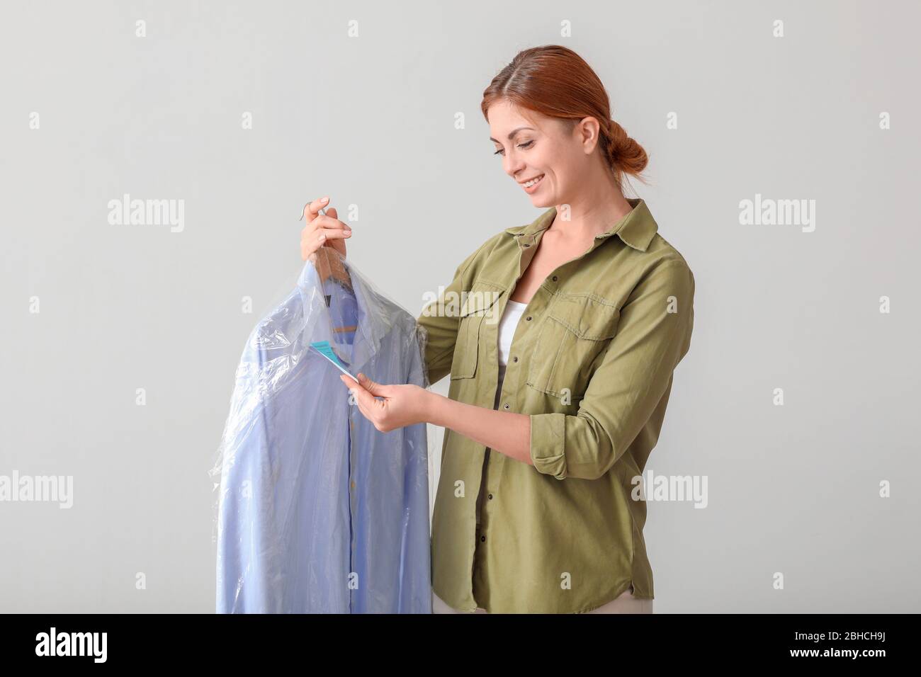 Worker of modern dry-cleaner's on light background Stock Photo - Alamy