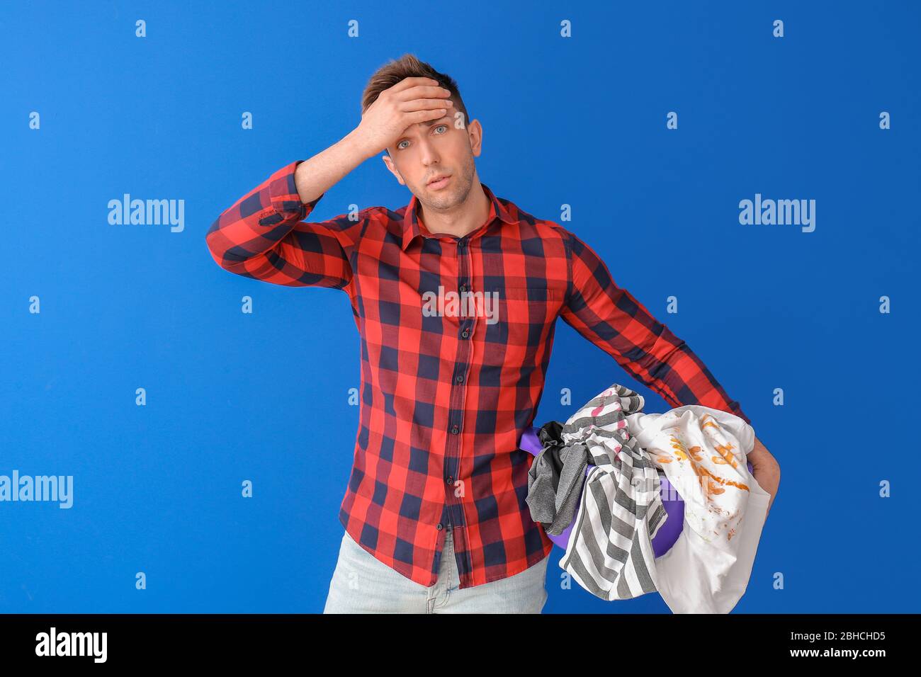 Sad man with dirty clothes on color background Stock Photo - Alamy