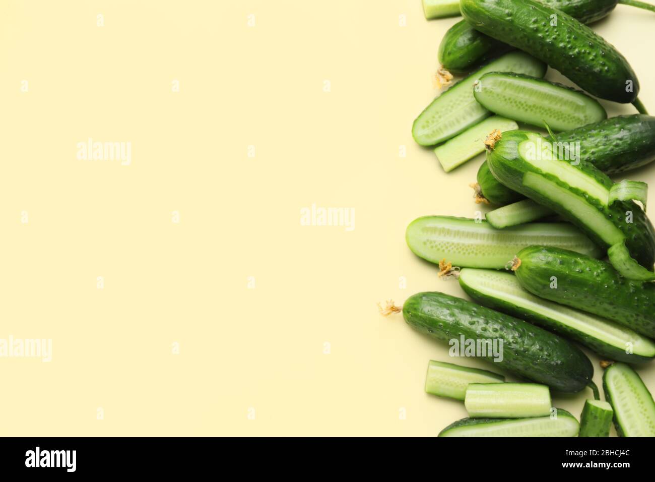Green cucumbers on color background Stock Photo - Alamy
