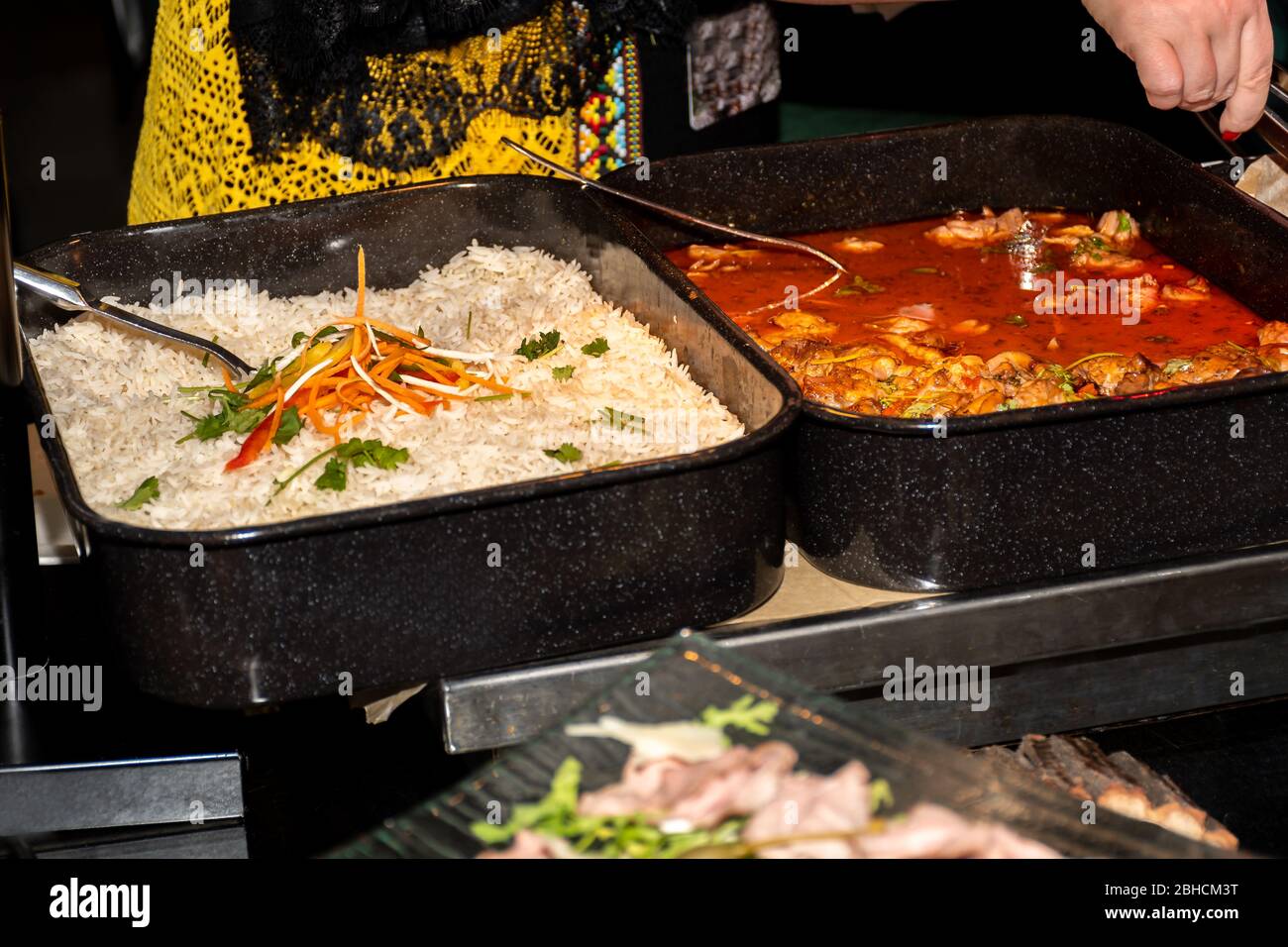 People around table during brunch buffet with hands, putting foods on ...