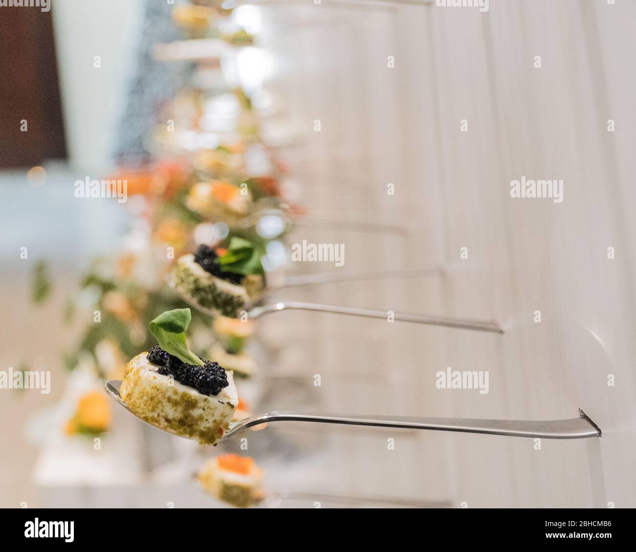 Tasty canapes plates in line hanging with caviar and cream cheese ...