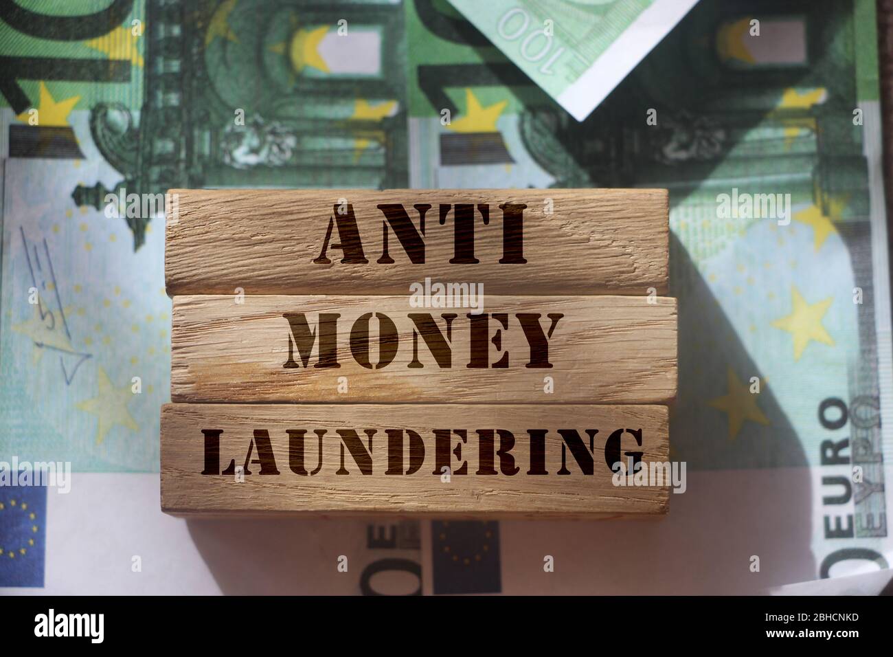 Anti Money laundering concept, words on wooden blocks on 100 euro ...