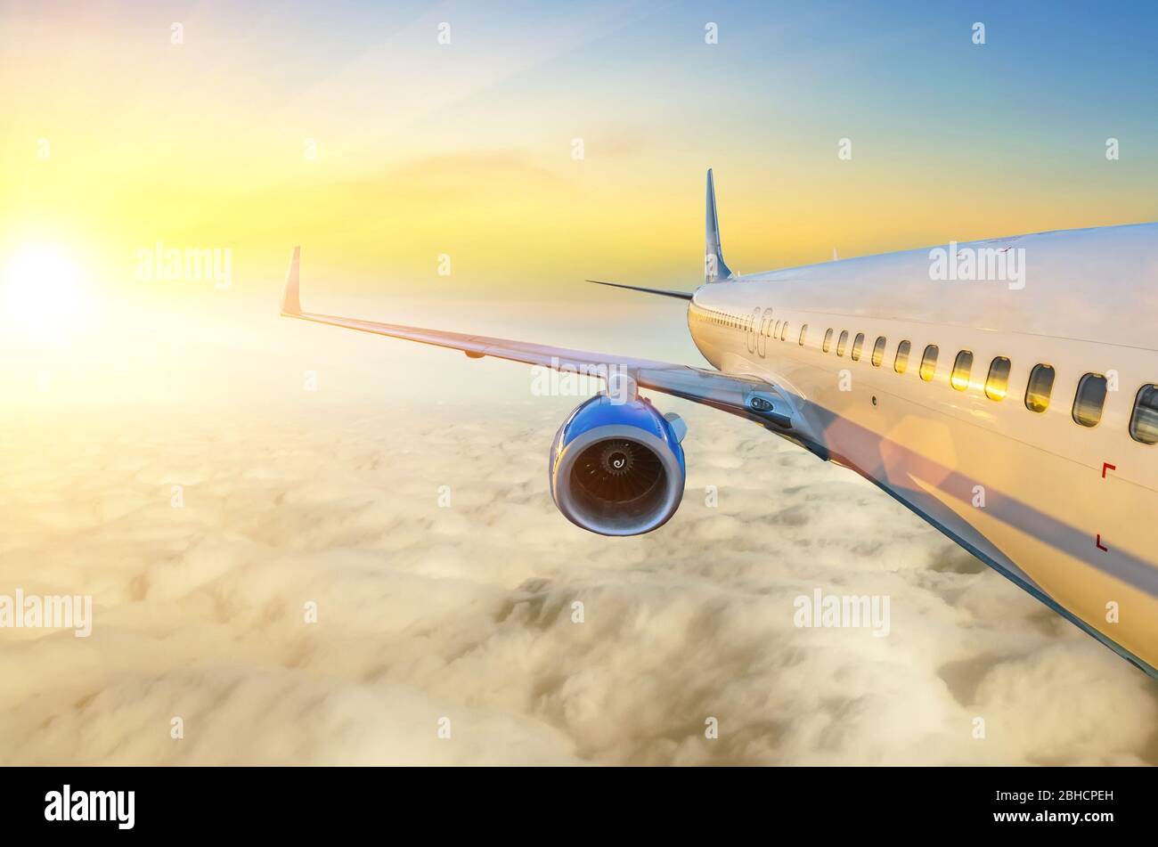 Airplane in the sky at sunrise view of the wing and engine Stock Photo ...