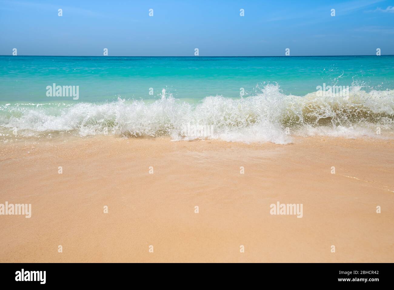 Beautiful sea waves on gold sandy beach and crystal clear water. Fine ...