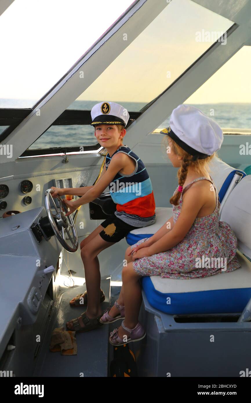 Portrait of children driving a yacht Stock Photo - Alamy