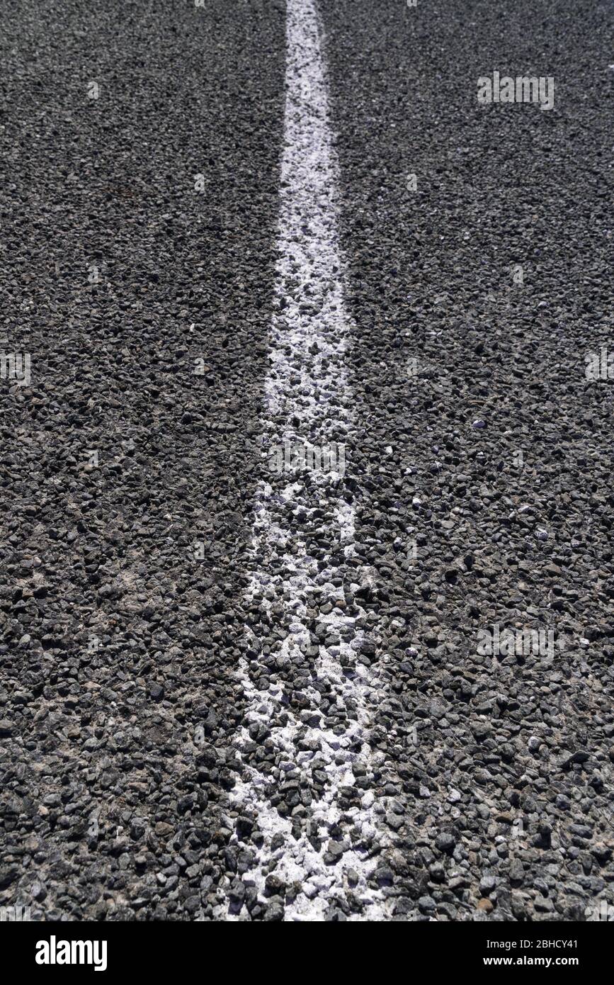 White Painted vertical road marking to the centre of the image running ...