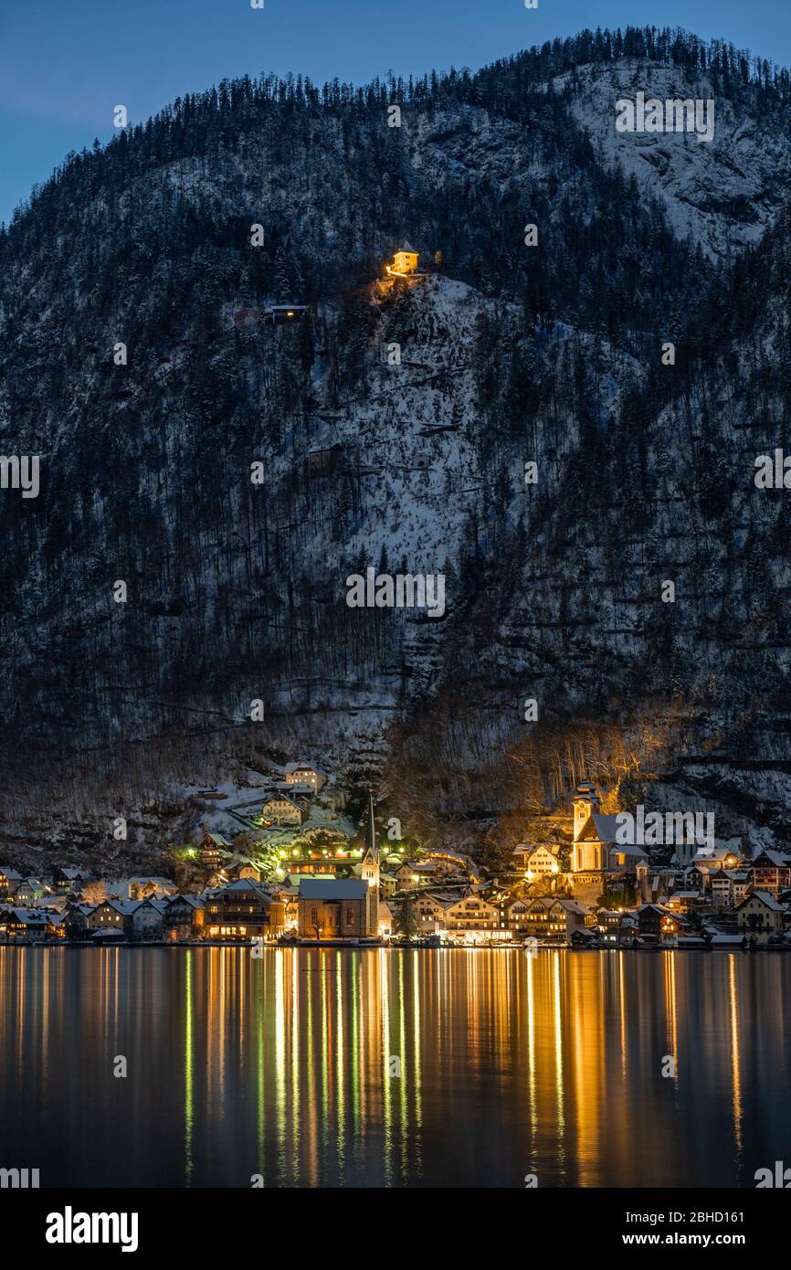 Beautiful Austrian village Hallstatt by lake covered with snow in ...