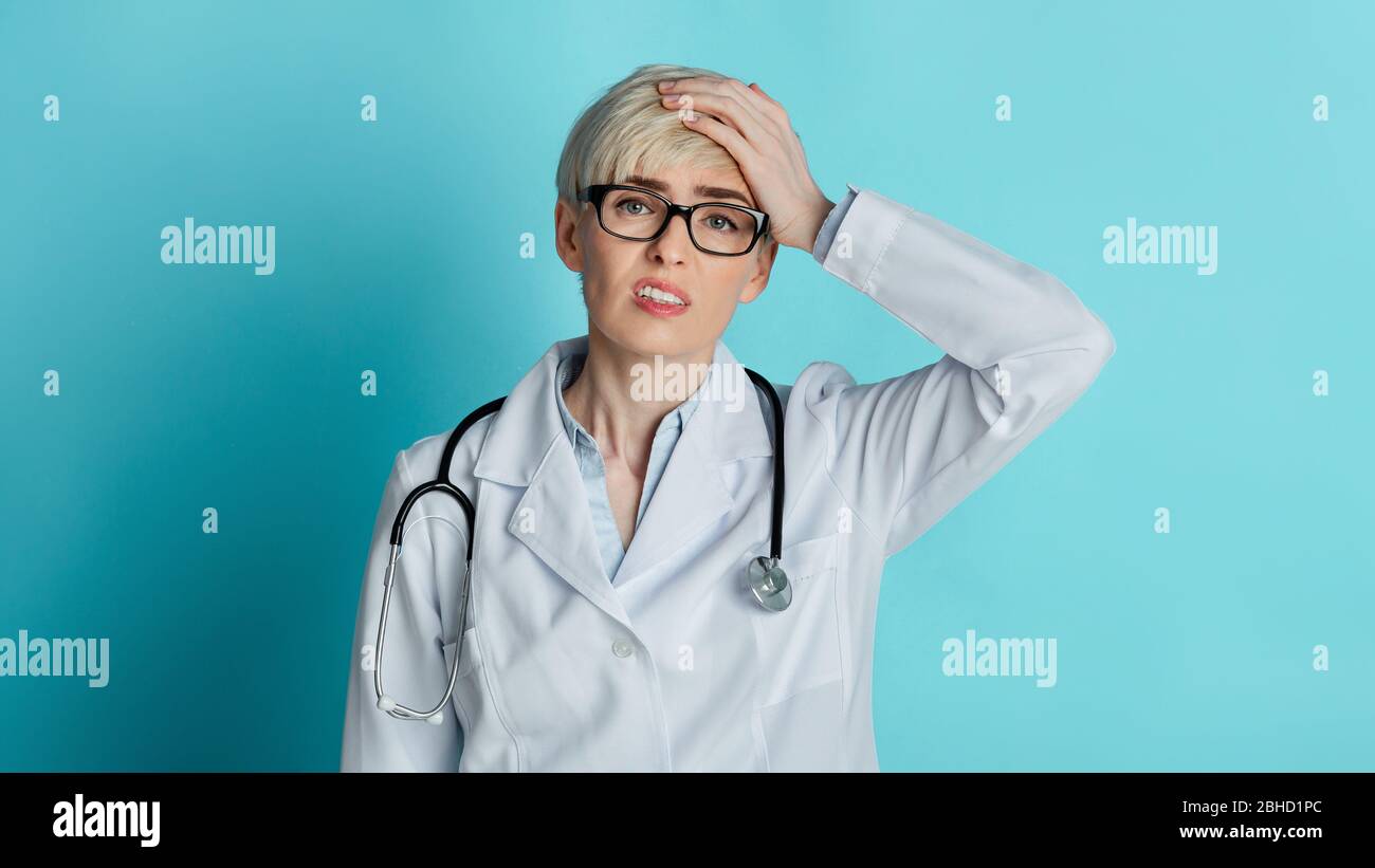 Problems in medicine. Upset woman doctor holding to head Stock Photo ...