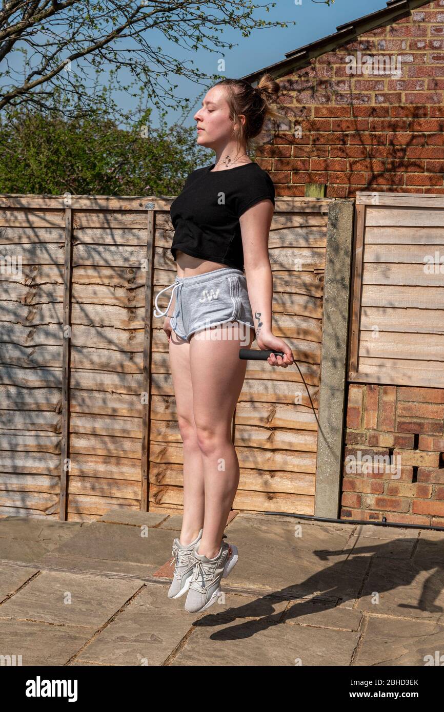 A young lady skipping in her agrden during coronavirus lock-down Stock ...
