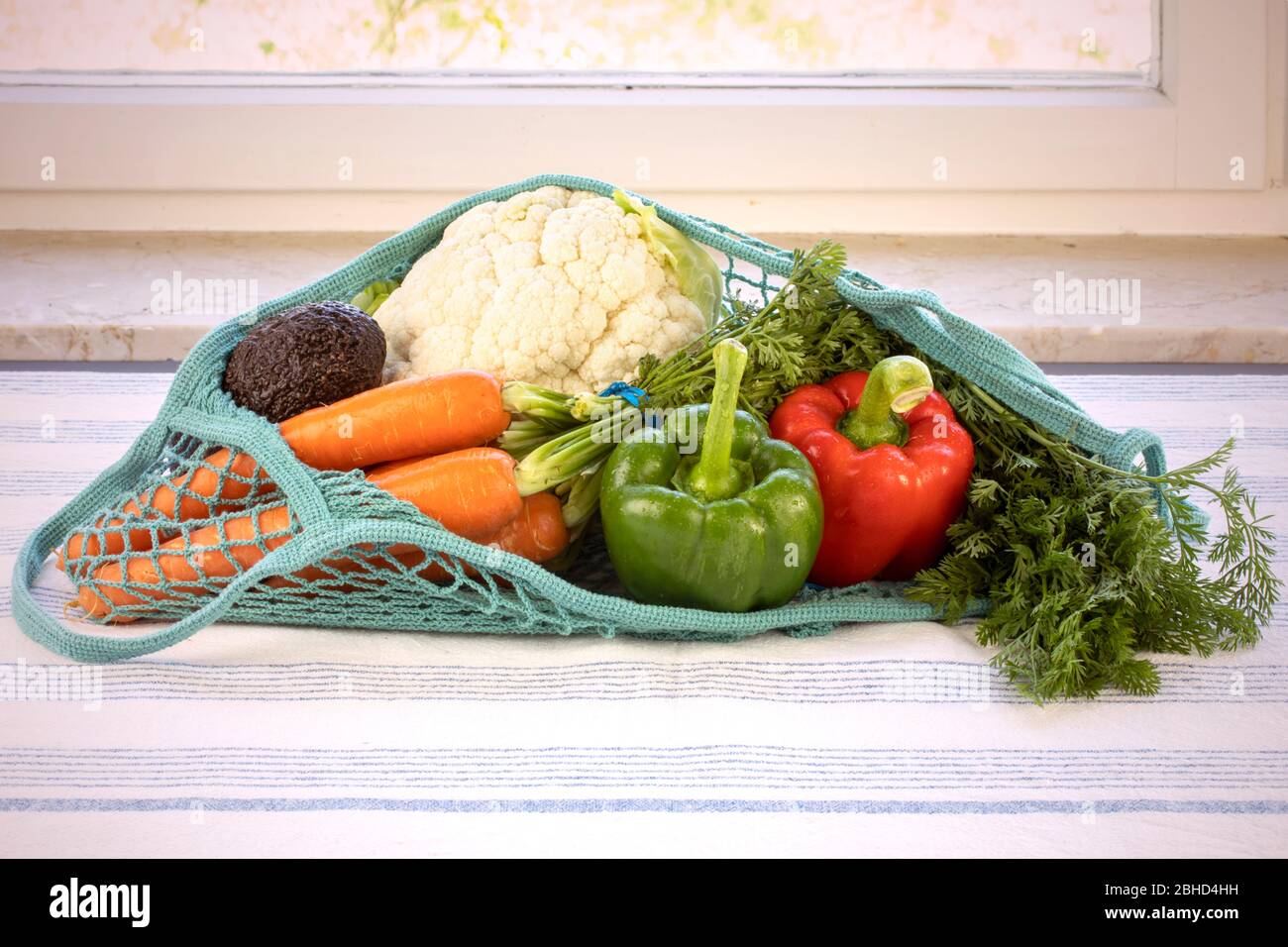 Fresh vegetables in a blue mesh bag, Reusable, sustainable, eco ...