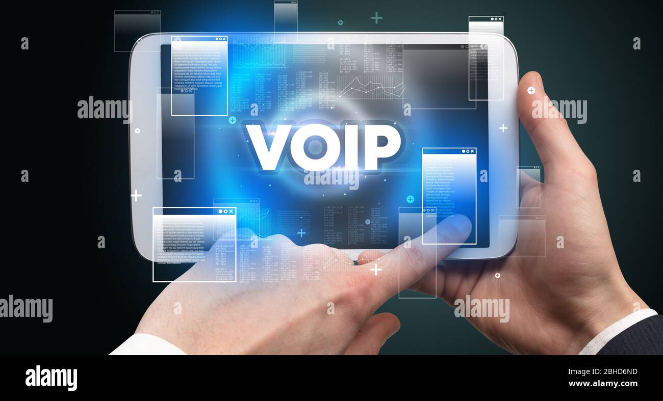 Close-up of a hand holding tablet with VOIP abbreviation, modern ...