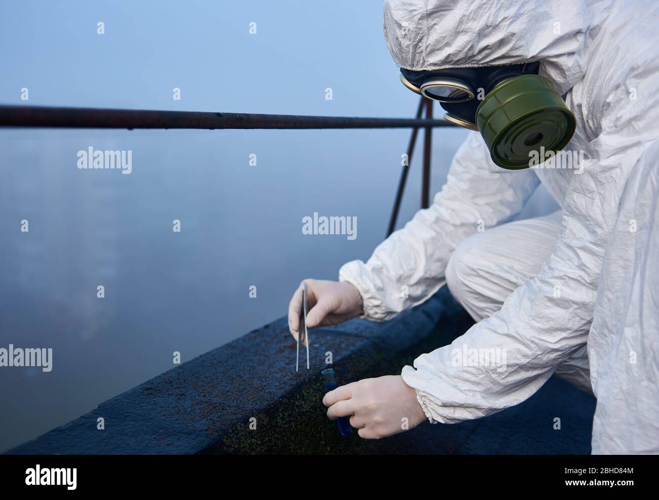 Researcher collecting samples for analysis in contaminated area, close ...