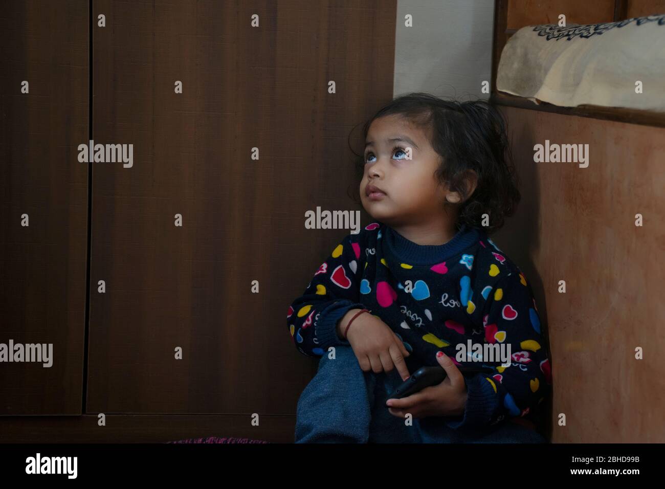 indian unhappy child sitting in corner with mobile Stock Photo - Alamy