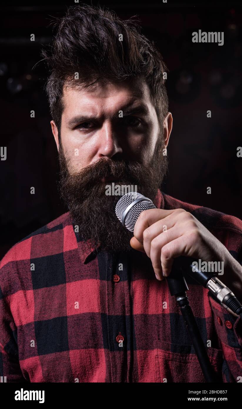 Vocalist concept. Musician with beard and mustache lighted by spotlight ...