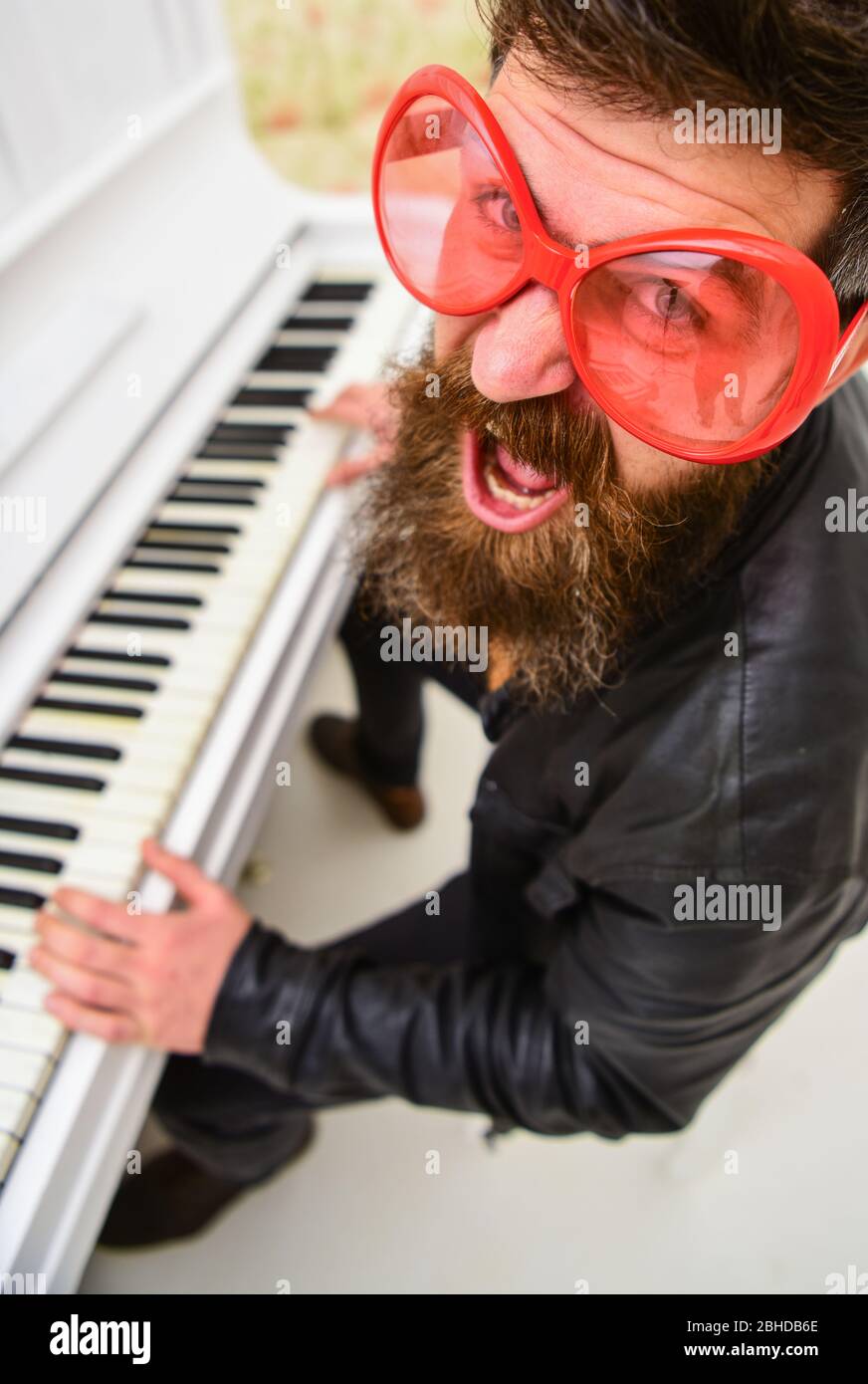 Man, cheerful pianist playing. Guy in giant red sunglasses while ...