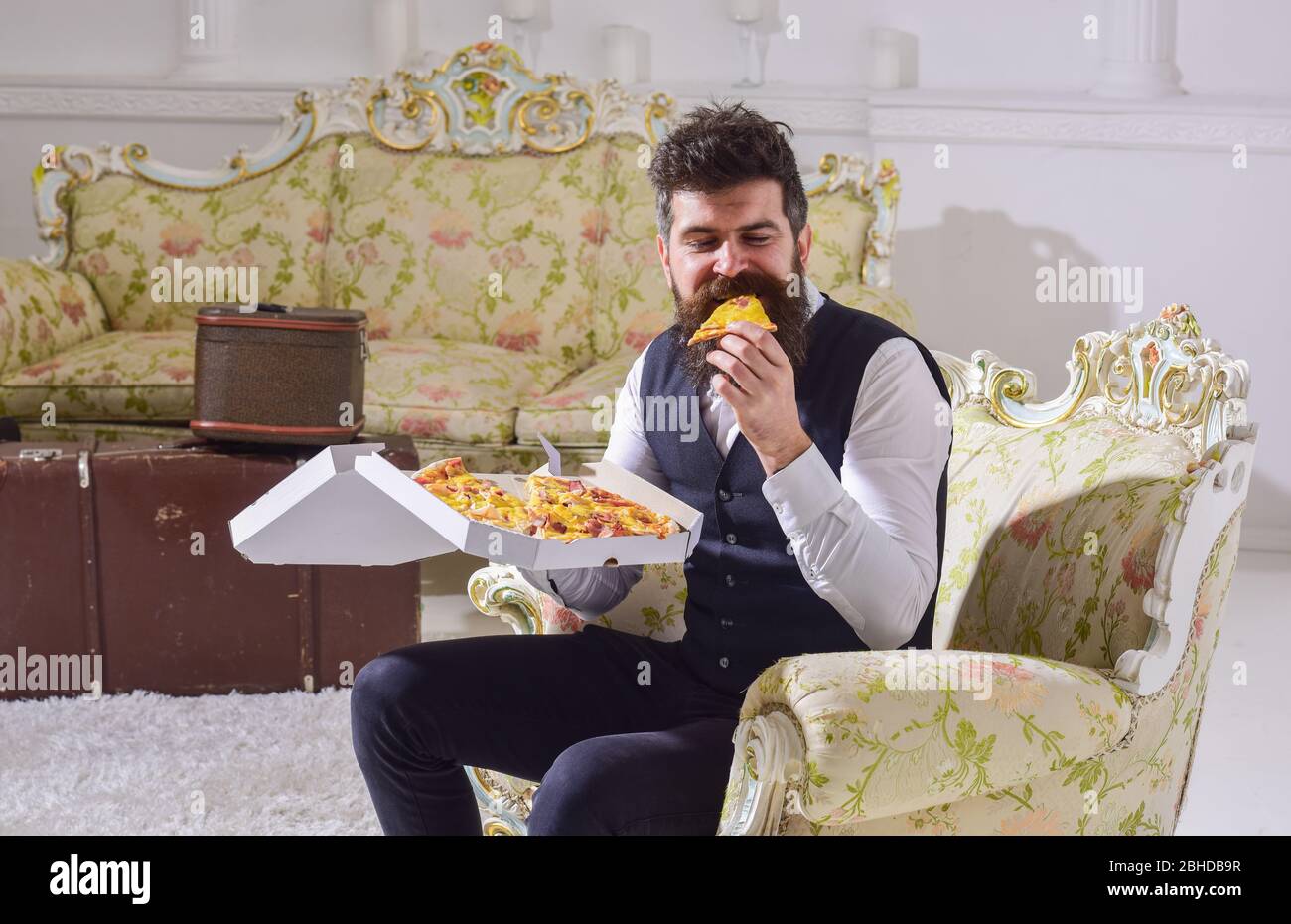 Man with beard and mustache holds box with tasty fresh hot pizza. Macho ...