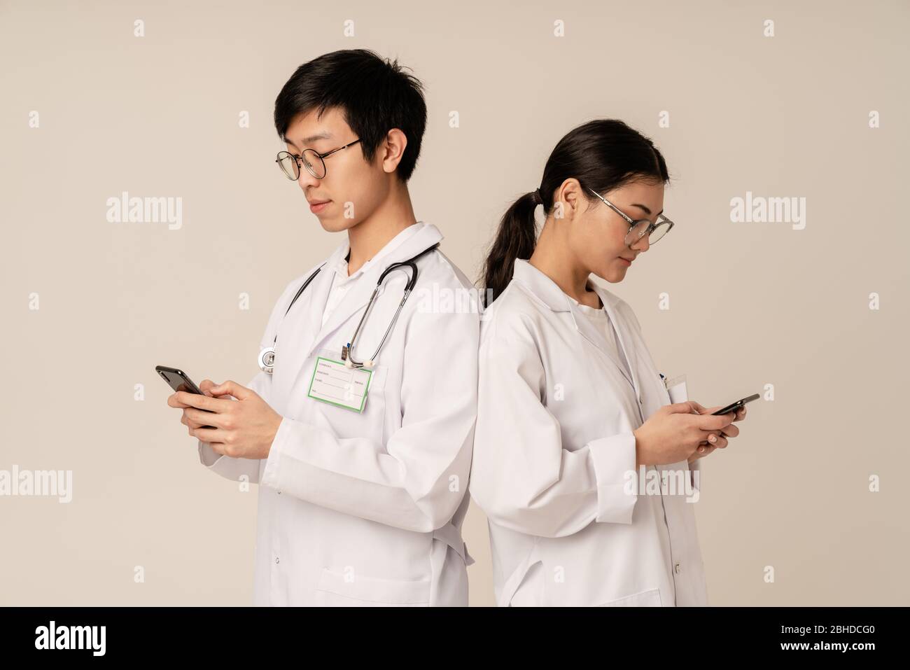 Image of asian young medical doctors in white uniform using cellphones ...