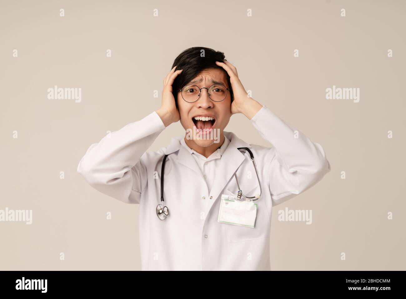 Image of asian young male doctor in medical white uniform screaming and ...