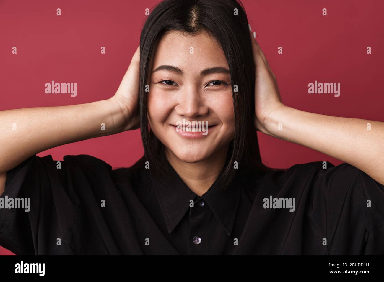 Image of an asian positive happy young woman covering ears posing ...