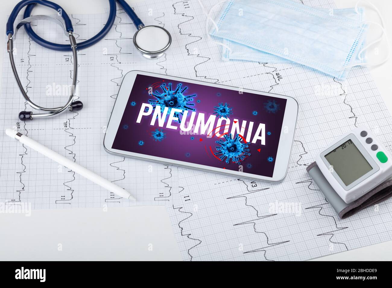 Tablet pc and doctor tools on white surface with PNEUMONIA inscription ...