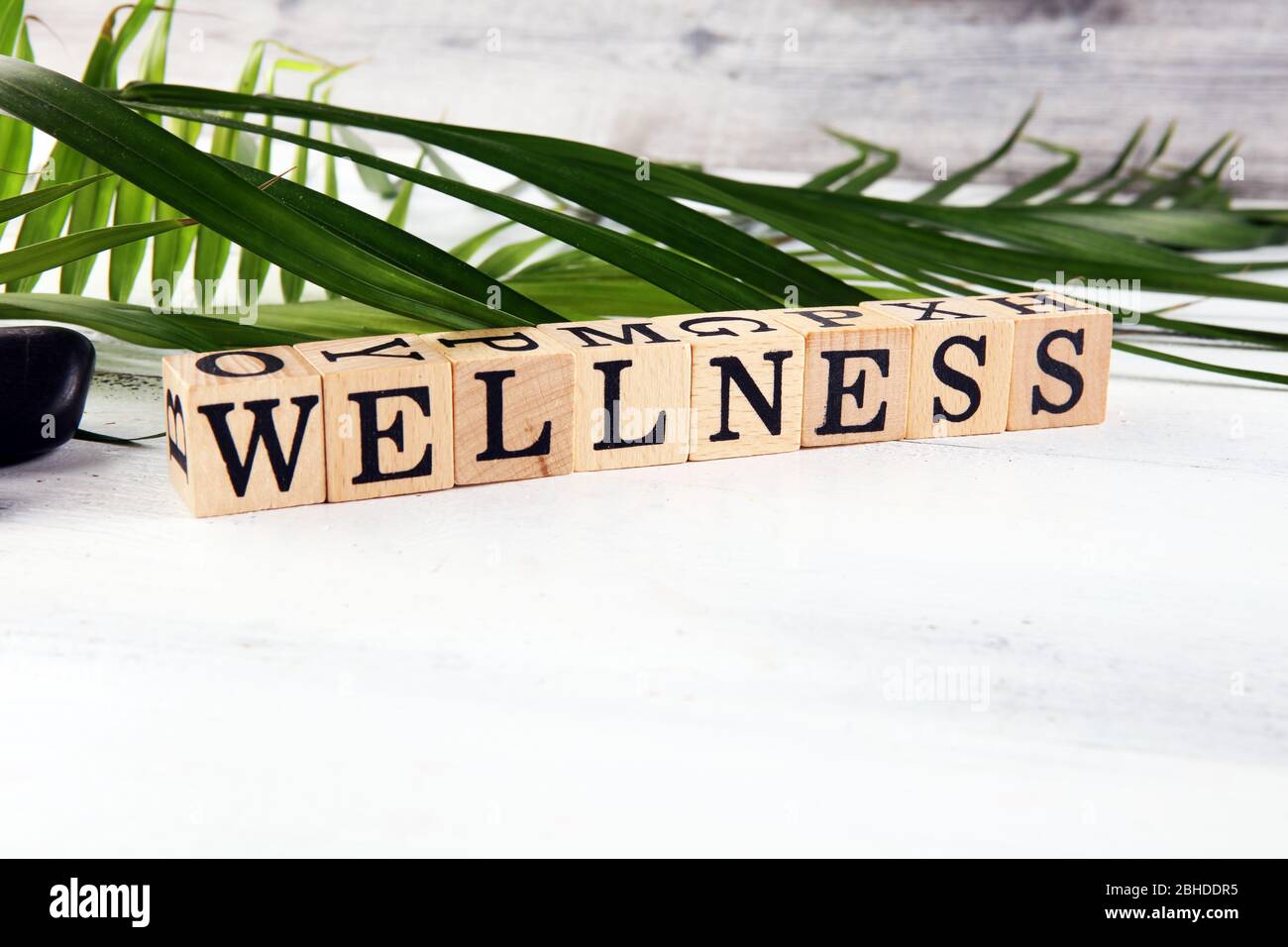 Wellness sign with wooden cubes with leaves and stones. Relax therapy ...