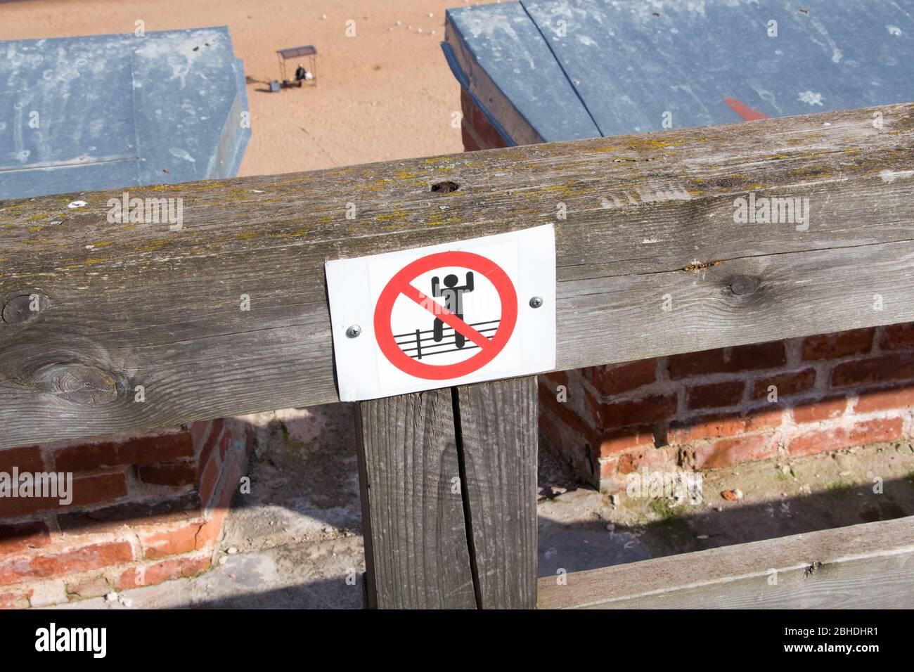 Warning sign on a wooden railing Stock Photo - Alamy