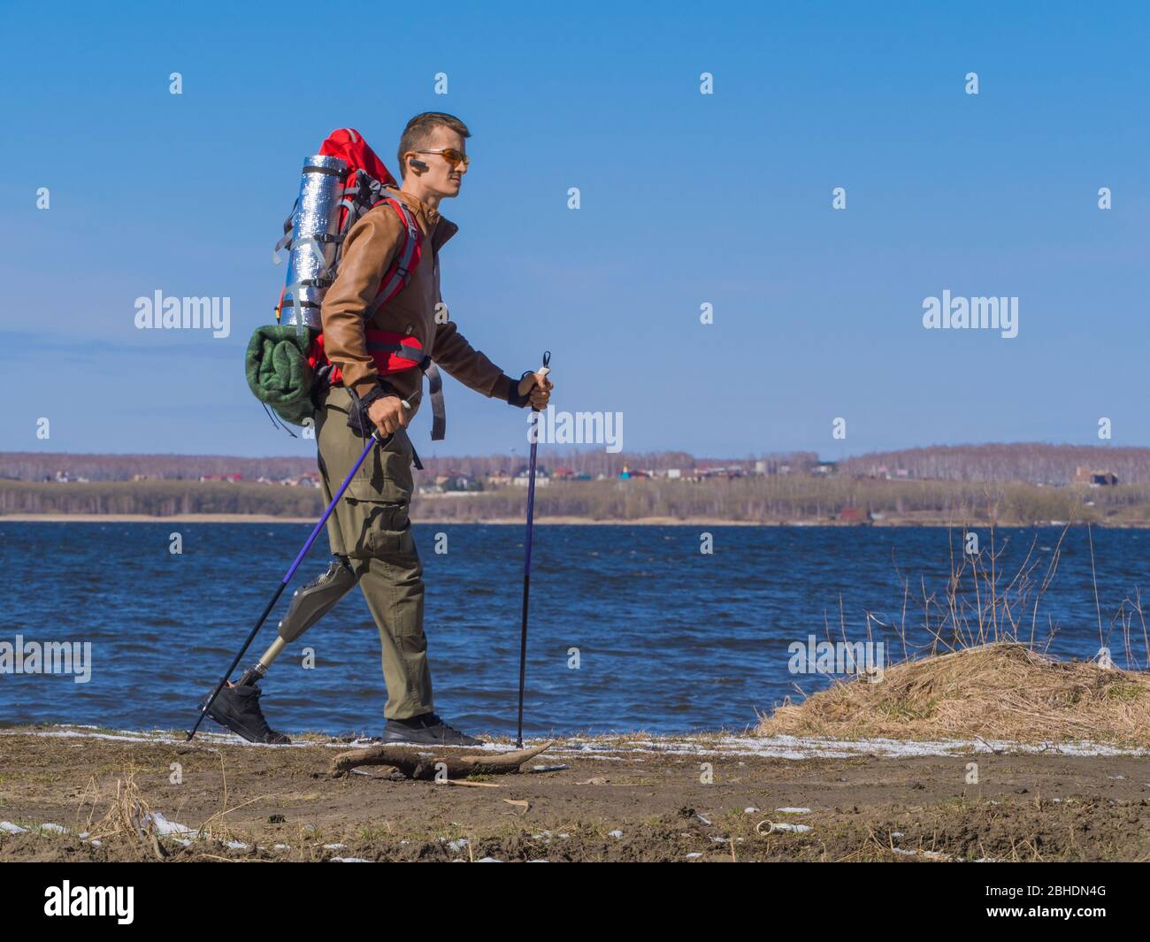 Side view of hiker with artificial leg. Strength, courage and ...