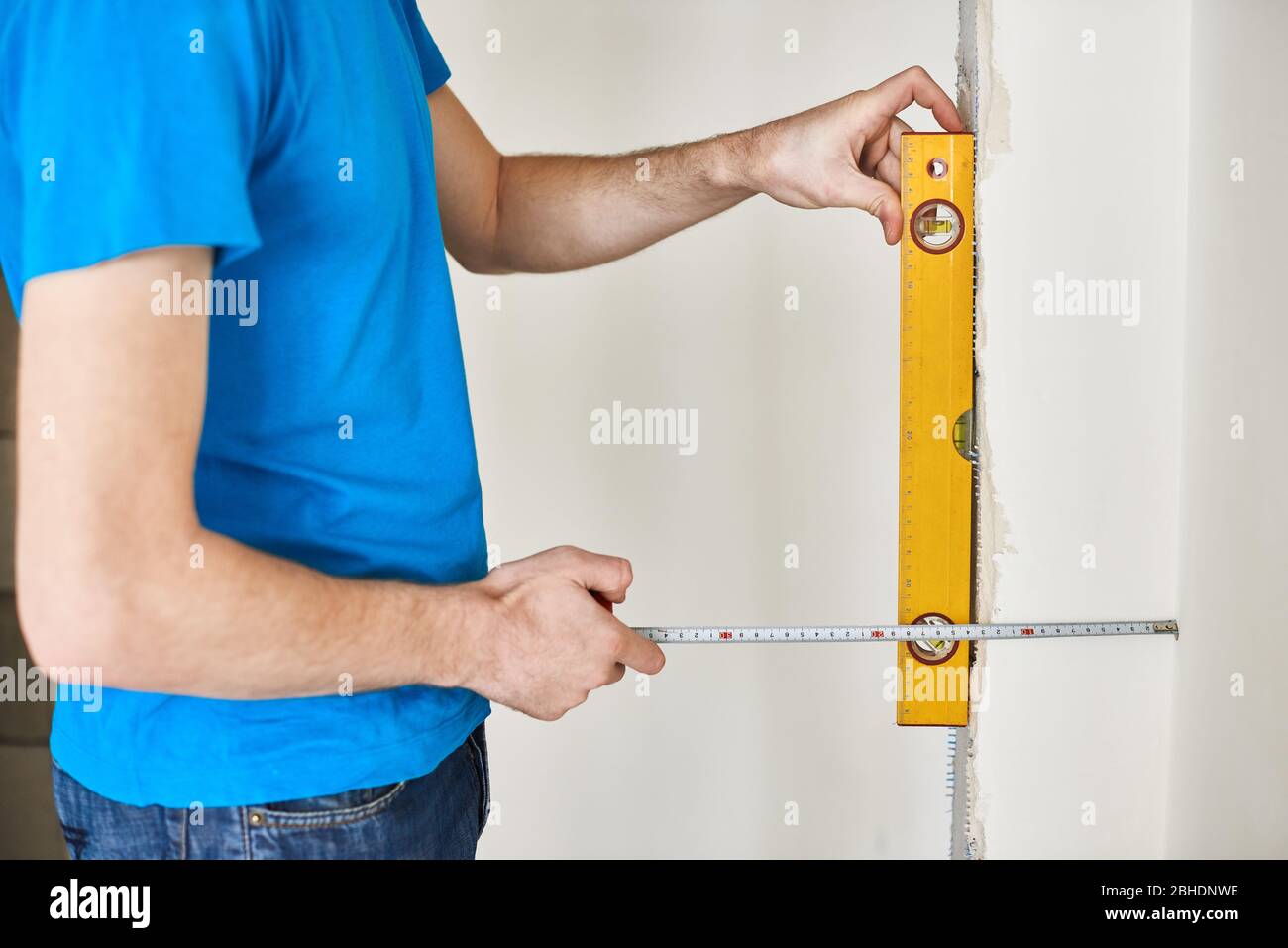 Man Using A Spirit Level To Plumb A Wall Home Renovation Concept