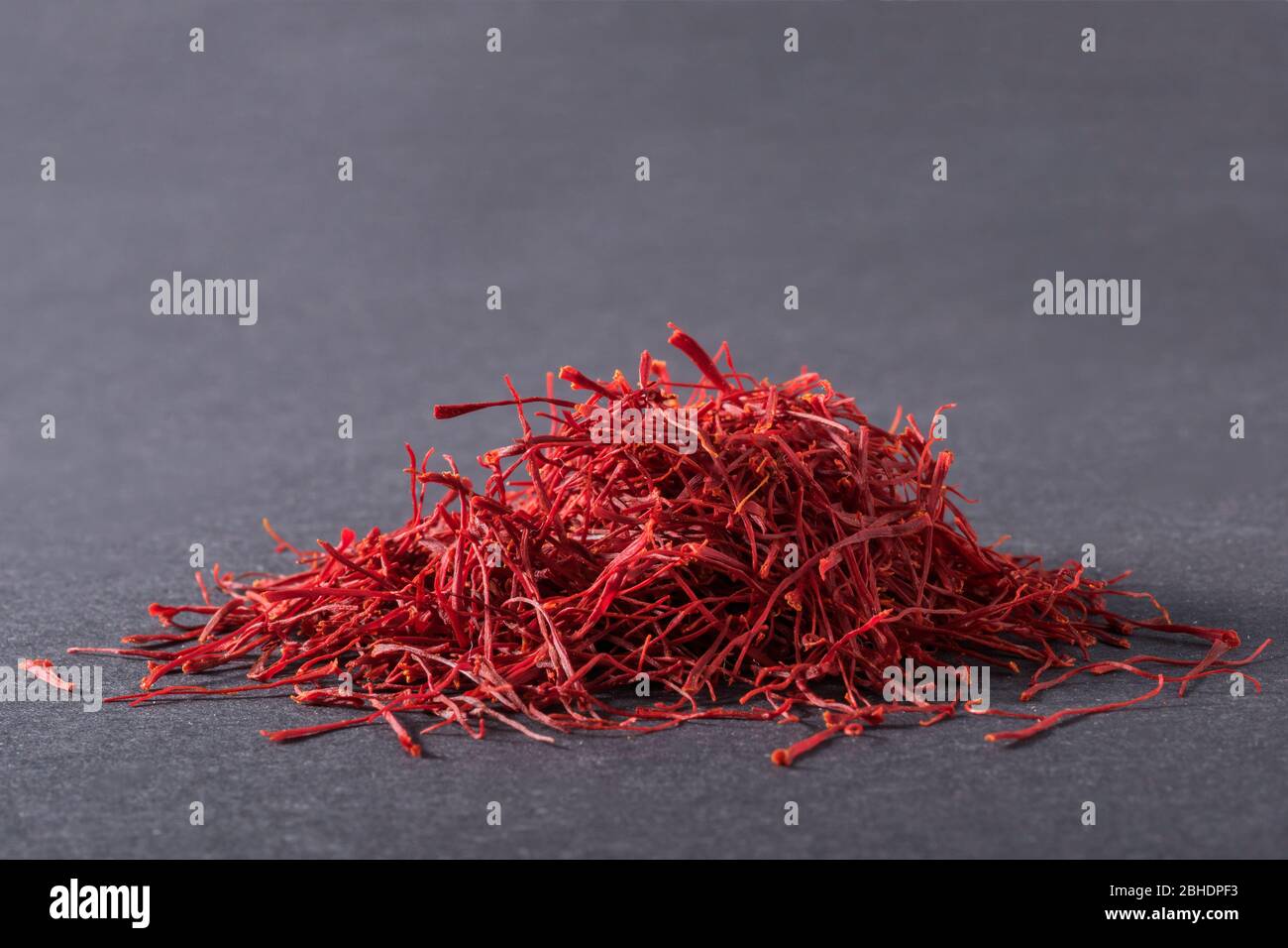 Saffron crocus threads on black background. Side view Stock Photo - Alamy