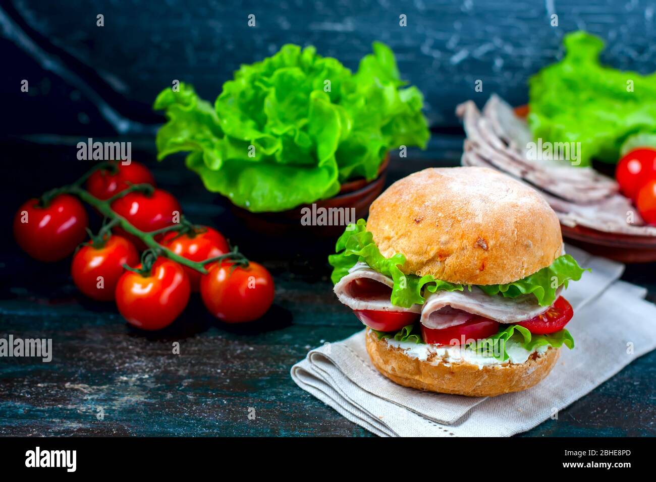 Homemade sandwich with ham and vegetables on wooden background ...