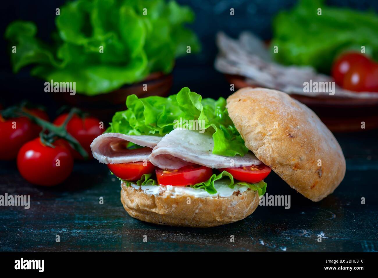 Homemade sandwich with ham and vegetables on wooden background ...