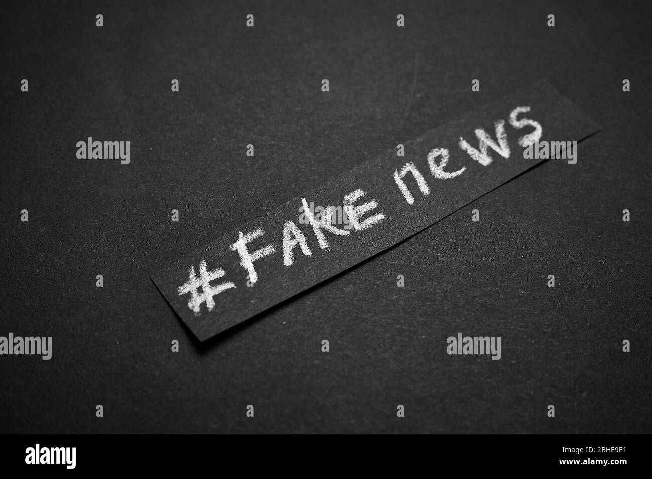 Fake news. The name is written in white chalk on a black background in ...