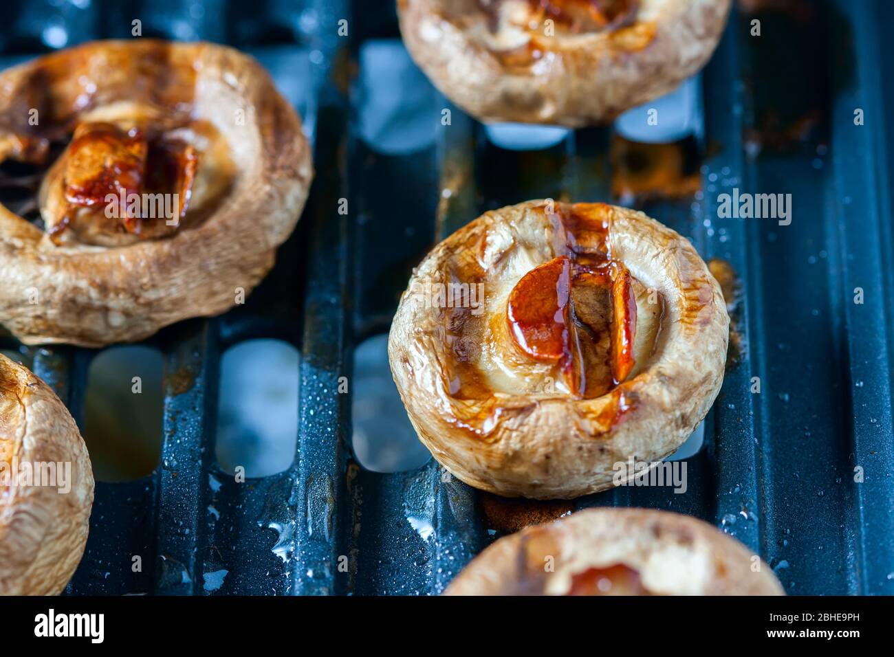 Champignon white mushrooms grilled. Grilled vegetables on a grill close ...
