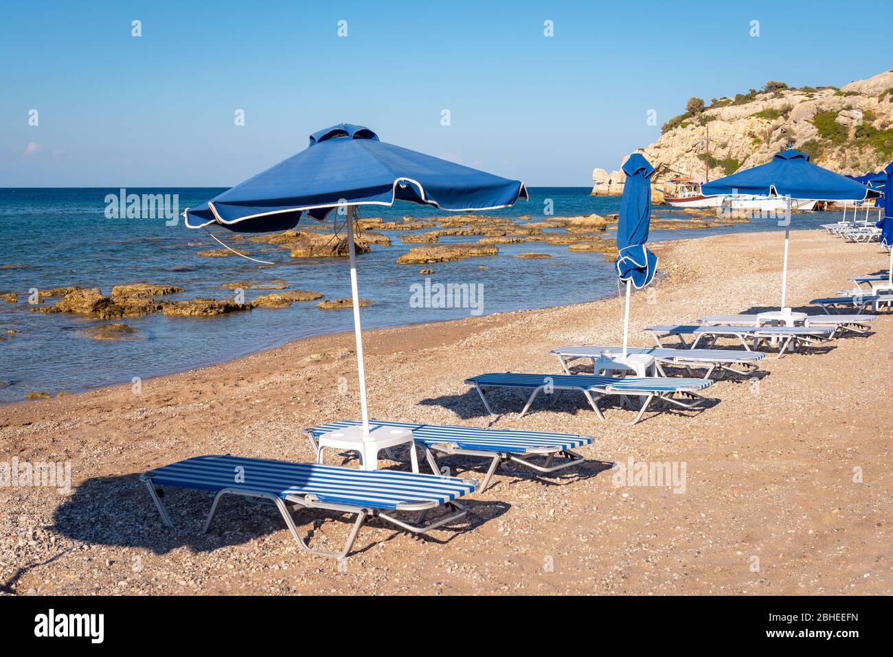 Sun loungers with umbrella on beautiful Kolymbia beach. Rhodes island ...