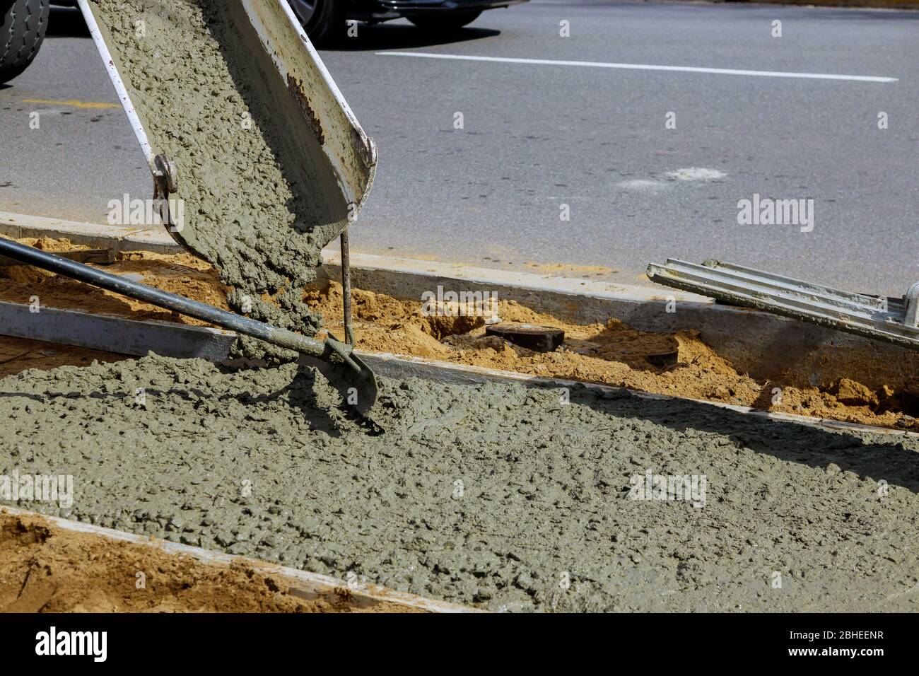 Worker construction truck mixer pouring concrete cement for sidewalk ...