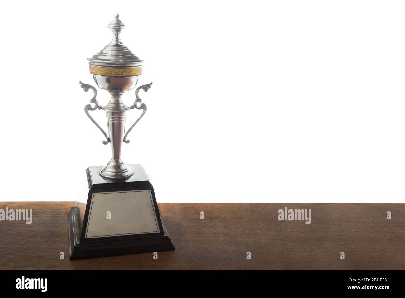 Golden trophy on wooden table isolated over white background. Winning ...