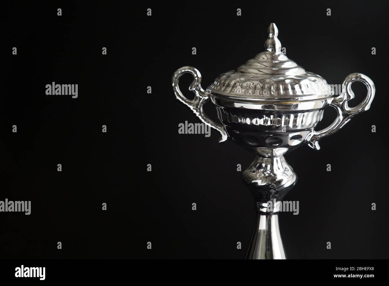 Close up of Silver trophy over black background. Winning awards with ...