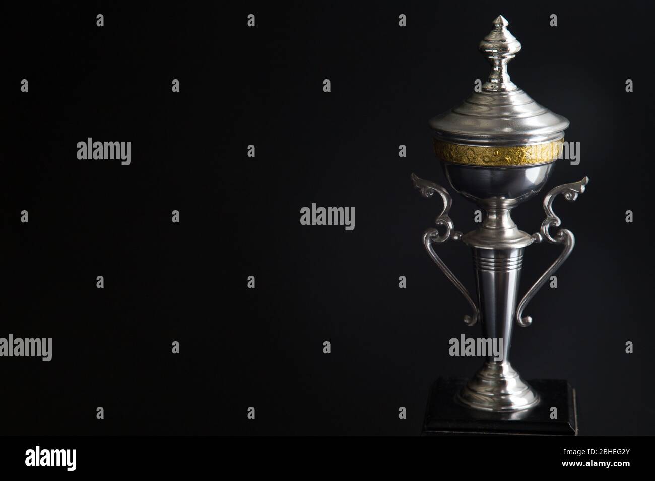 Close up of Silver trophy over black background. Winning awards with ...