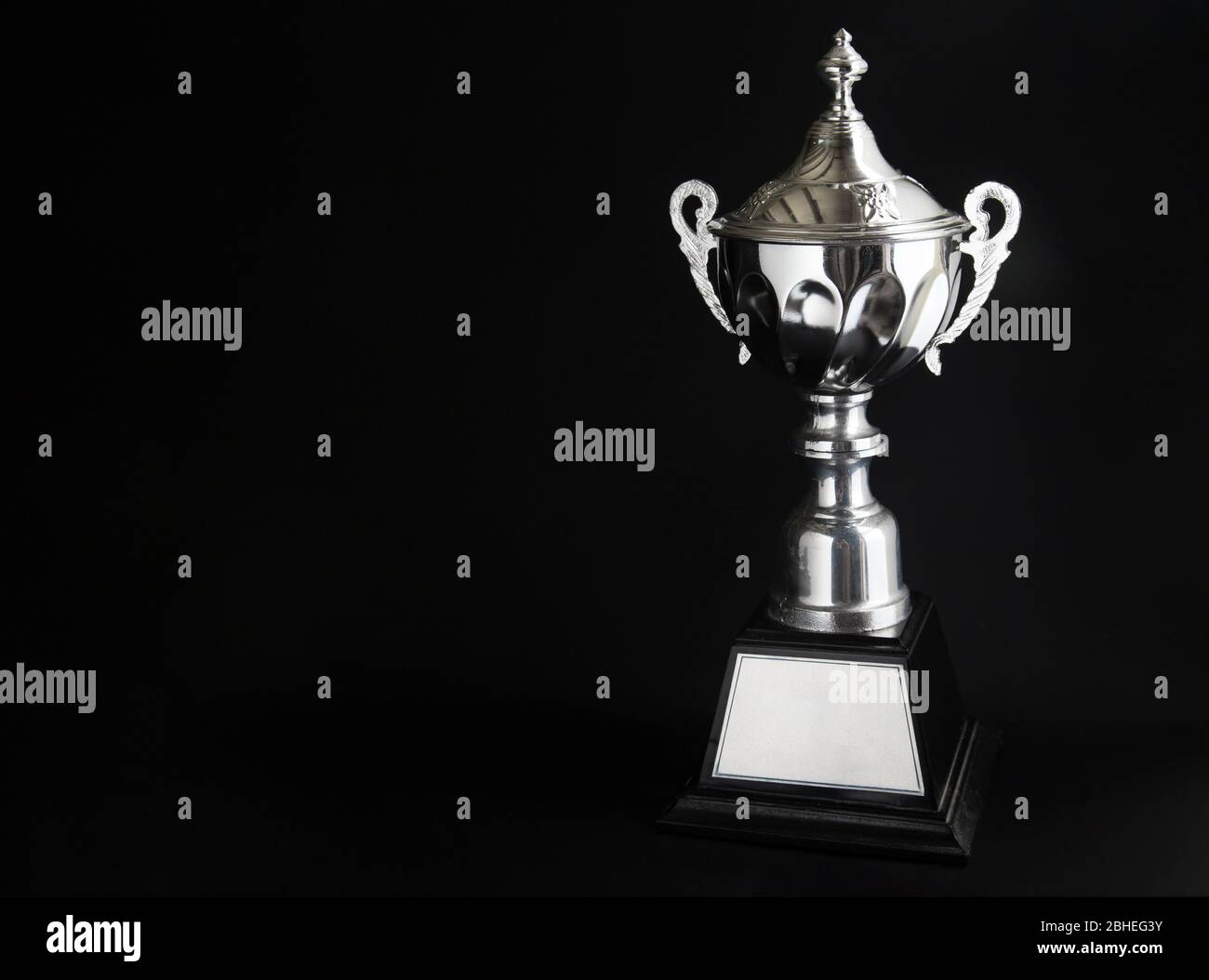 Silver trophy over black background. Winning awards with copy space for ...